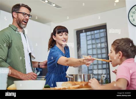 They Love Moms Cooking Shot Of A Mother Giving Her Son A Taste Of The