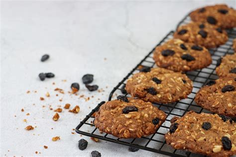 갓 구운 수제 귀리 및 건포도 쿠키의 행의 이미지 금속 와이어 냉각 랙 부스러기와 건포도로 둘러싸인 대리석 효과 배경 높은 전망 전경에 초점 복사 공간 건포도에 대한 스톡