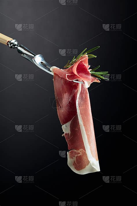 用叉子切成薄片的迷迭香熏火腿。