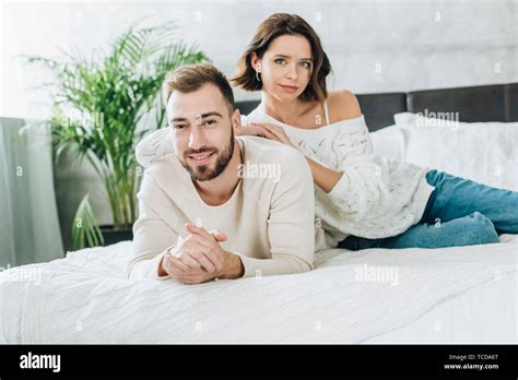 Happy Bearded Man With Clenched Hands Looking At Camera With Attractive