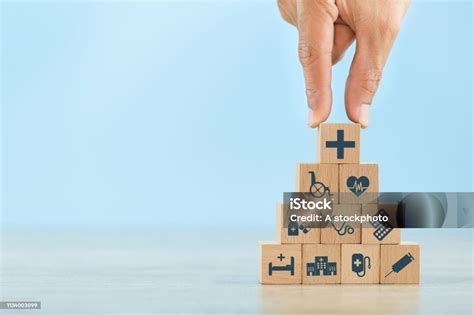 健康保険コンセプトアイコンヘルスケア医療と木材ブロックスタッキングを手で配置 しずくのストックフォトや画像を多数ご用意 しずく