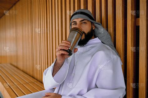 年轻的阿拉伯人坐在木凳上