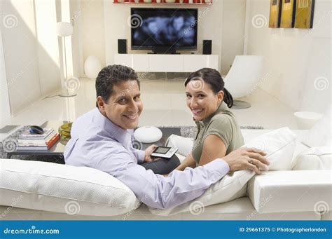 Couple With Remote Control Sitting On Sofa Stock Image Image Of