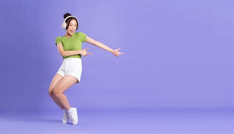 ピンクの背景にポーズをとる美しいアジアの女の子の全身画像 ダンスのストックフォトや画像を多数ご用意 ダンス ヘッドフォン 女性