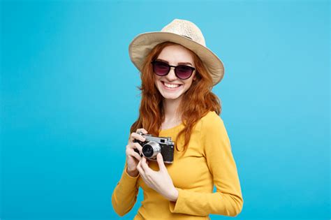 여행 컨셉세로 젊은 아름 다운 매력적인 Redhair 여자 최신 유행 모자 선 글래스와 빈티지 카메라 카메라에 미소를 닫습니다