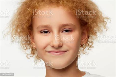 하얀 스튜디오 배경에 고립 된 흰색 티셔츠를 입은 어린 소녀 웃는 어린 소녀의 클로즈업 어린이 감정의 개념 6 7 살에 대한