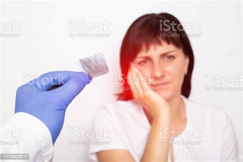 치과 의사는 치아의 통증과 염증이있는 소녀의 배경에 대해 치아의 Pulpitis 환자의 X 선을 보유하고 복사 공간 이빨에 대한