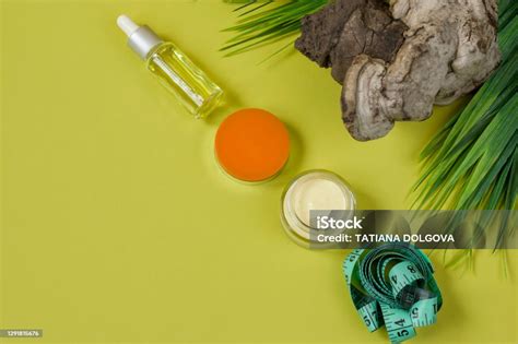 차가 자작나무 버섯은 화장품의 유행 개념입니다 천연 크림 노란색 배경에 유리 용기에 차가와 에센셜 오일 Naturopathy 스파 천연 항산화제 플랫 레이 개념에 대한 스톡