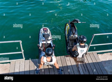 Two Personal Watercraft Rider Sit On The Pier In The Marina Port Vell