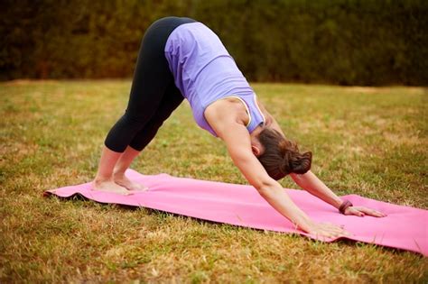 Mujer joven haciendo yoga en el parque esta mujer estirada está en buena forma Foto Gratis