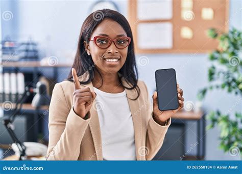 African Young Woman Holding Smartphone Showing Blank Screen Surprised