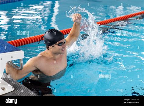 Caucasian Young Male Swimmer Celebrating Indoors In Pool Splashing
