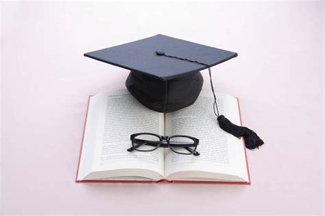 无人学生横图俯视室内特写白天静物书籍一本一副阴影粉色背景反射眼镜影子黑色书本打开翻开摄影流苏影棚