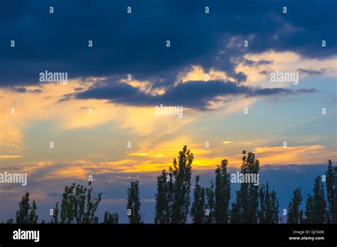 Landscape With Dramatic Light Orange Clouds And The Outline Of Trees At Sunset Stock Photo Alamy