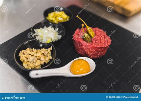 Elaborate Smoked Beef Tartare Served On Black Wooden Board With Egg
