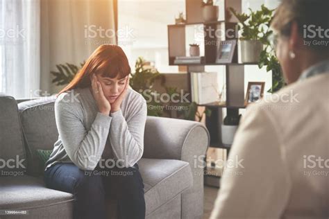 심리학자 또는 치료사와 이야기하는 여성 카운슬러와의 치료 세션 중에 도움을 받으면서 슬퍼하는 청녀 요법에 대한 스톡 사진 및
