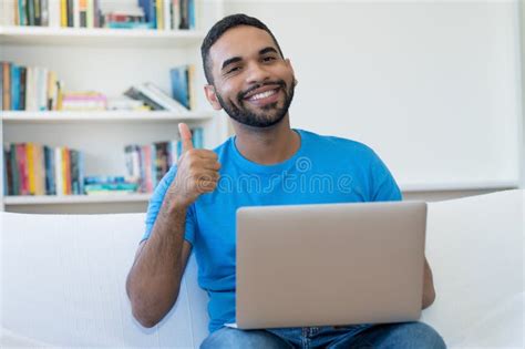 Laughing Latin American Male Programmer At Work At Computer Stock Image