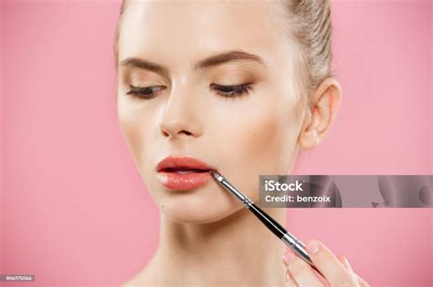 뷰티 개념핑크 스튜디오 배경으로 빨간 립스틱을 적용 하는 여자 아름 다운 여자 화장은 거울에 대한 스톡 사진 및 기타 이미지 거울 관능 립스틱 Istock