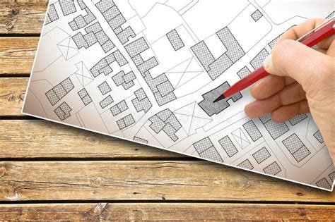 Hand Drawing An Imaginary Cadastral Map Of Territory With Buildings And Relief Map Over A Wooden
