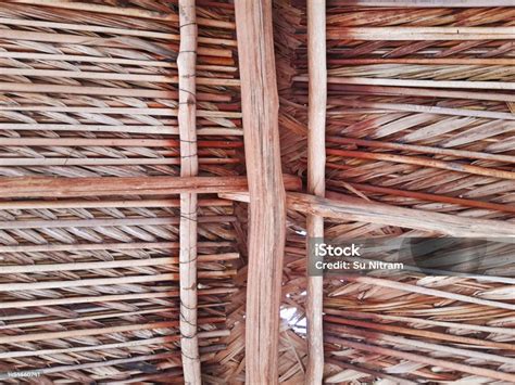 ヤシの葉の屋根の下からの眺め木わら乾燥した葉で作られた素朴な屋根の接写建築と熱帯建設干し草の屋根のテクスチャーストローパターン かやぶき