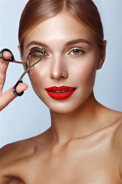 Beautiful Girl With Red Lips And Classic Makeup With Curler In Hand