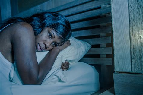 라이프 스타일 밤 여자의 초상화 젊은 슬 프 고 걱정 검은 아프리카계 미국인 침대 집에서 잠 못 드는 우울한 기분이 스트레스에 고통을 두통 및 우울증 이나 불면증 수 면