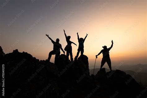 Silhouettes Of A Group Of Successful Climbers On The Top Of A Mountain