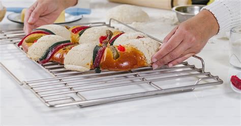 멕시코 여성은 멕시코 라틴 아메리카의 킹스 데이를 위해 집에서 부엌의 오븐에서 전통적인 Rosca De Reeyes 또는 주현절 케이크를 굽고 있다 사진 Unsplash