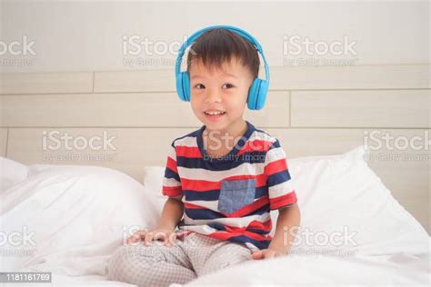 미소 아시아 3 4 세 유아 소년 아이 헤드폰과 춤에 음악을 듣고 줄무늬 티셔츠를 입고 18 23 개월에 대한 스톡 사진 및