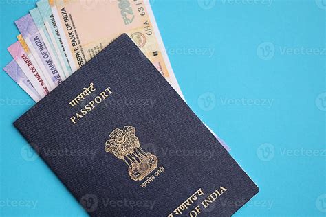 Blue Indian Passport And Indian Rupees Money Bills On Blue Background