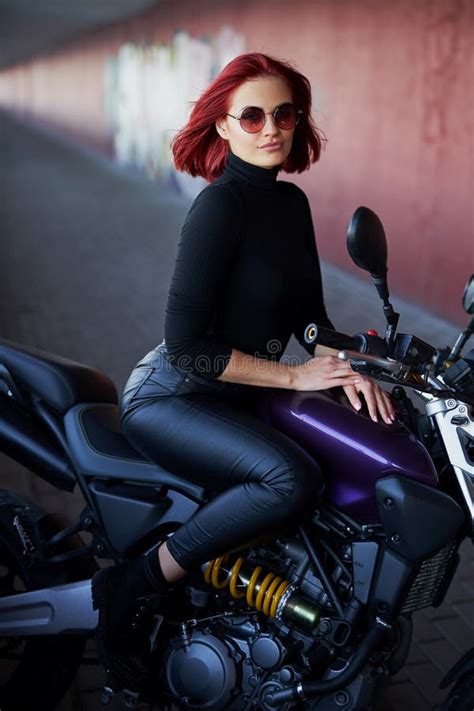 A Girl With Red Hairs Posing With Dark Urban Motorcycle Stock Image