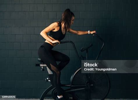 에어 바이크에서 강렬한 훈련을하는 근육질의 젊은 여성의 측면 보기 건강한 생활방식에 대한 스톡 사진 및 기타 이미지 건강한 생활방식 운동 20 29세 Istock