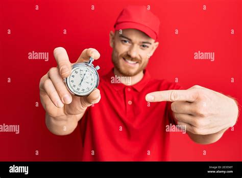 Young Redhead Man Wearing Delivery Uniform And Countdown Clock Smiling