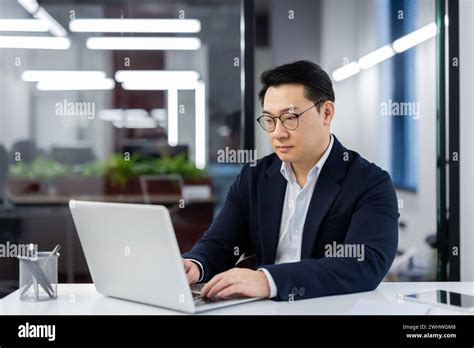 Serious Concentrated Asian Businessman Inside Office At Workplace Experienced Mature Boss In