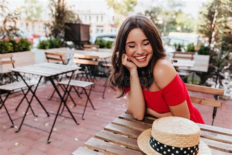 Excited Tanned Girl Looking At Her Straw Hat Outdoor Portrait Of