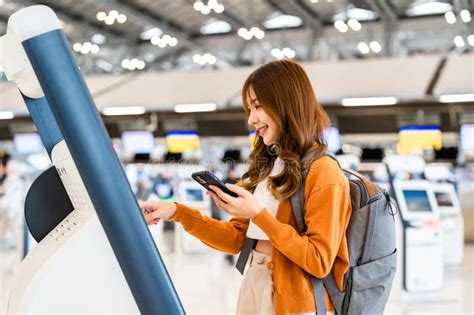 Young Asian Woman Using Self Check In Kiosks In Airport Terminal Stock