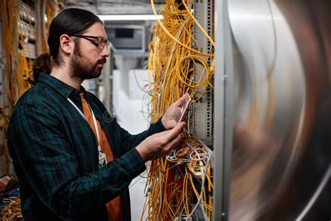 Bearded System Administrator Setting Up Server And Using Smartphone