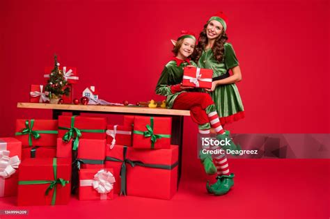 밝은 빨간 색 배경에 고립 된 포옹 공예 선물 상자를 들고 두 매력적인 쾌활한 친구 엘프의 전체 길이 몸 크기 보기 2명에 대한