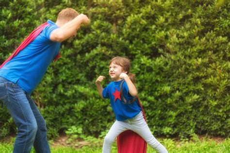 젊은 아빠 그리고 슈퍼 히어로 의상 주말에 파크에서 함께 재생에 귀여운 소녀 Superdad 개념입니다 2명에 대한 스톡 사진