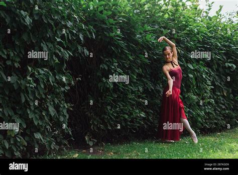 Woman Ballerina In Red Ballet Dress Dancing In Pointe Shoes Posing Next
