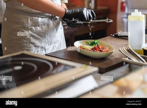 Professional Chef Grates Parmesan Cheese On Ready Dish In Restaurant
