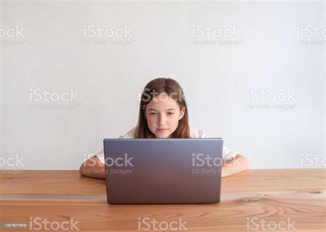 나무 테이블에서 집에서 노트북을 사용하는 어린 소녀 교육 온라인 학습 가정 학습 거리 학습 전면 보기 노트북에 대한 스톡 사진