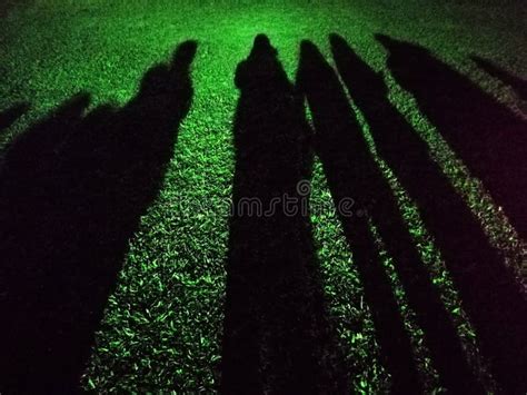The Shadow Of Many People On The Green Lawn At Night People Shadows
