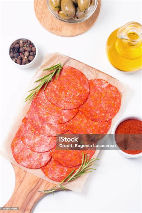 Chorizo 소시지와 살라미 얇은 컷 향신료 파프리카 로즈마리 및 올리브가있는 나무 배경에 스페인 살라미 매운 음식