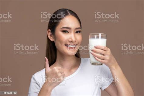 아시아의 아름다운 여자 귀여운 소녀는 베이지색 배경에 행복을 느끼며 건강을 위해 우유를 마시는 행복을 느낀다 20 24세에 대한 스톡 사진 및 기타 이미지 Istock
