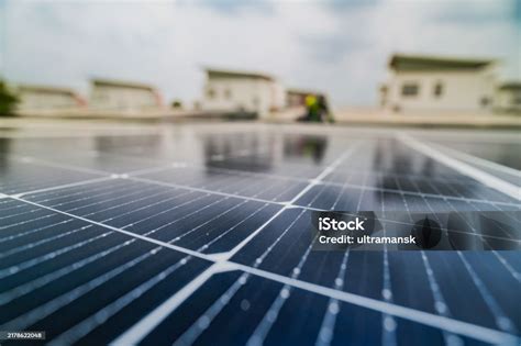 작업자가 배경에 흐릿하게 표시된 태양 전지판의 클로즈업 패널의 초점은 재생 에너지 기술과 태양 광 발전 설비의 중요성을 강조합니다 공장 산업 건물에 대한 스톡 사진 및 기타