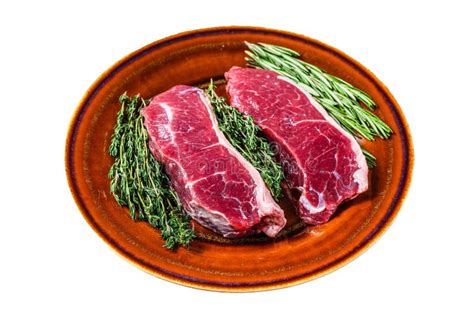 Raw Strip Loin Beef Meat Steak On A Plate With Herbs Isolated On White