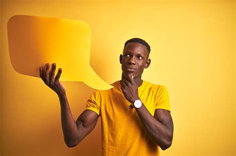 질문에 대해 생각 하는 고립 된 노란색 배경 심각한 얼굴 위에 서 연설 거품을 들고 젊은 아프리카 계 미국인 남자 매우 혼란 스러운 아이디어 개념에 대한 스톡 사진 및 기타