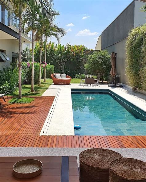 An Outdoor Swimming Pool Surrounded By Palm Trees And Other Greenery In
