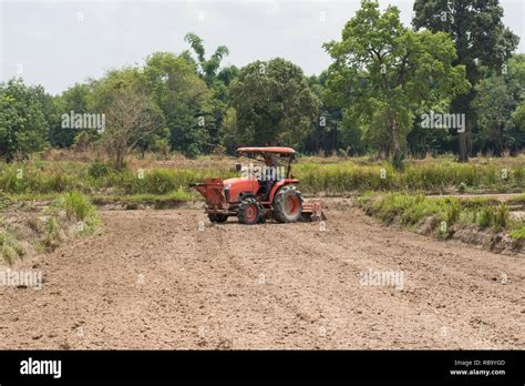 Thai Farmers Are Using A Tractor To Prepare The Soil For Growing Rice